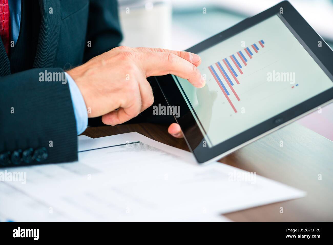 Business - banker, Manager or expert evaluates the figures on tablet ...
