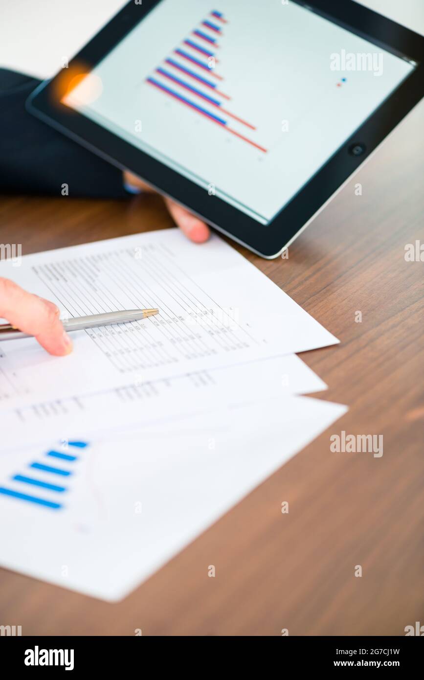 Business - banker, Manager or expert evaluates the figures on tablet ...