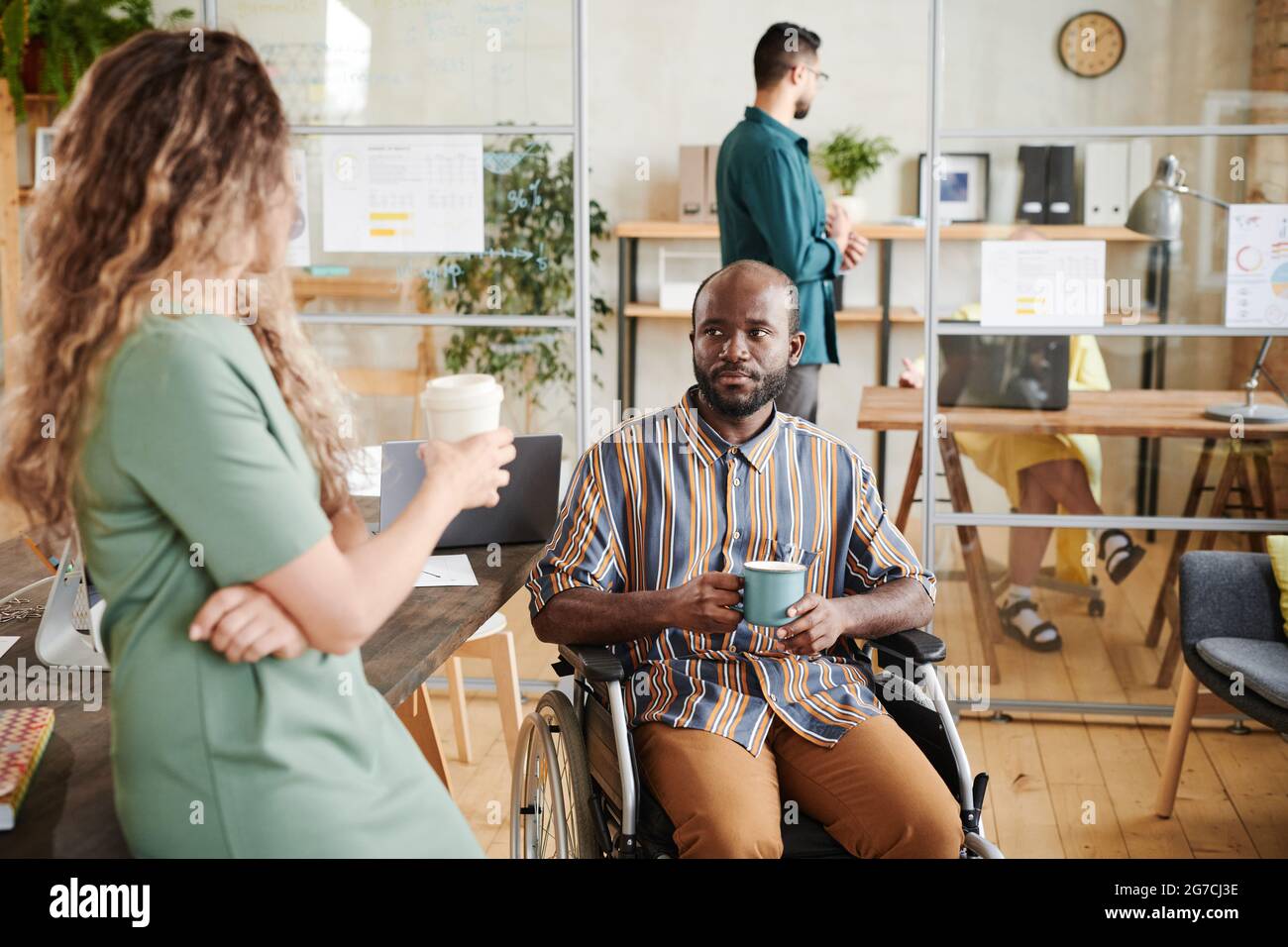 Business colleagues talking to each other and drinking coffee at office ...