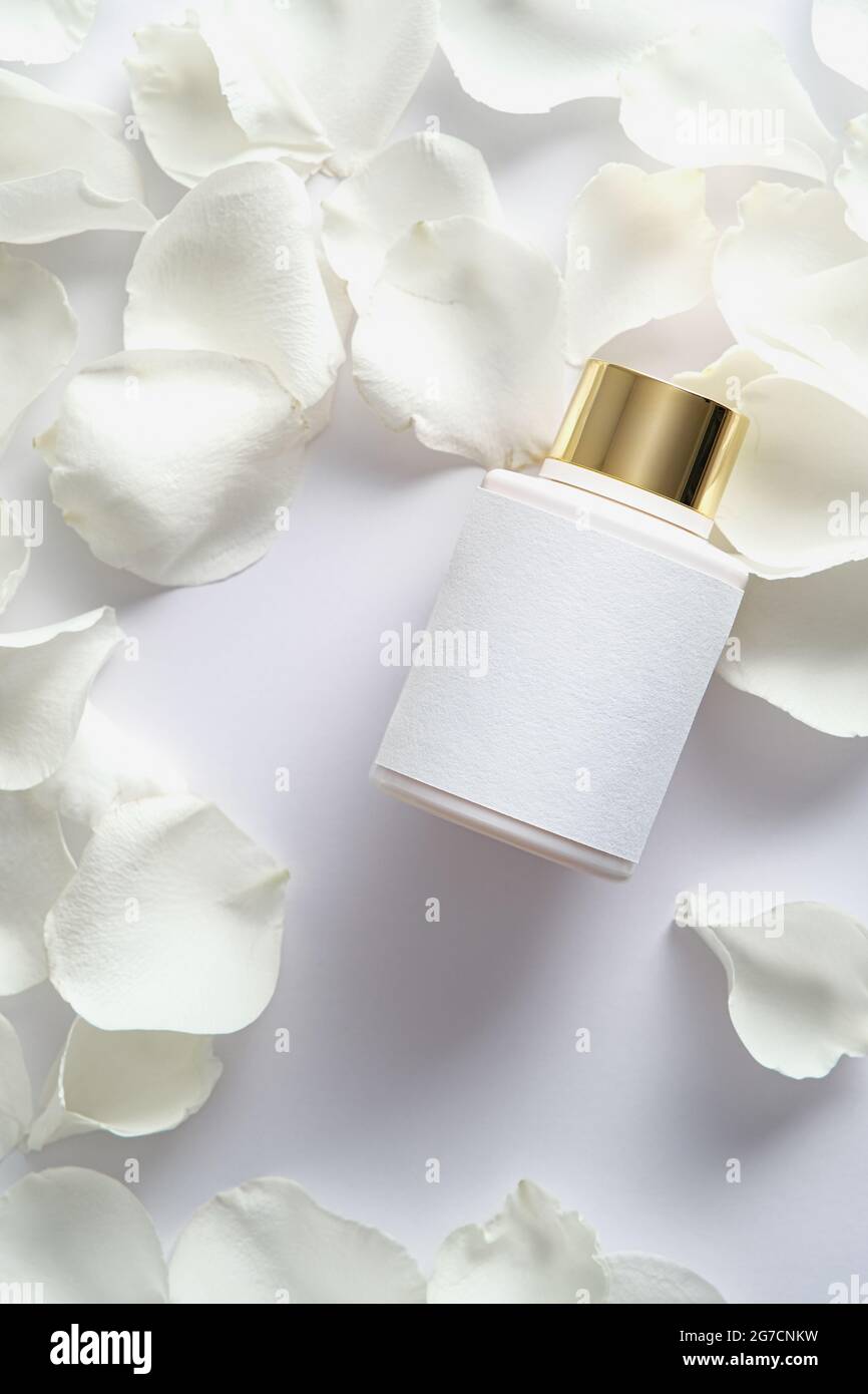 Luxury cosmetic lotion bottle mockup and rose petals on white ...
