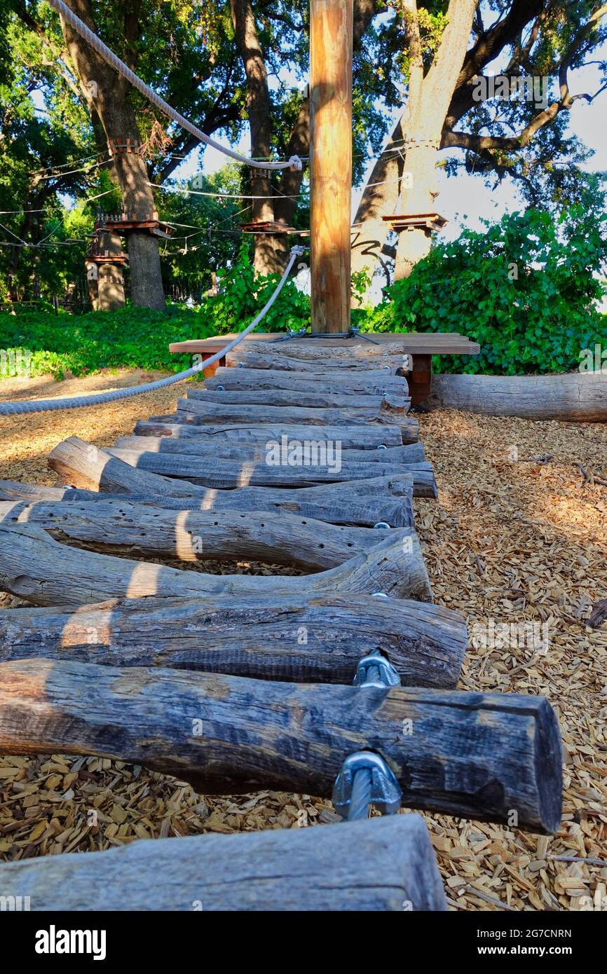 Vertical shot of tree logs with ropes for exercising in a park on a ...