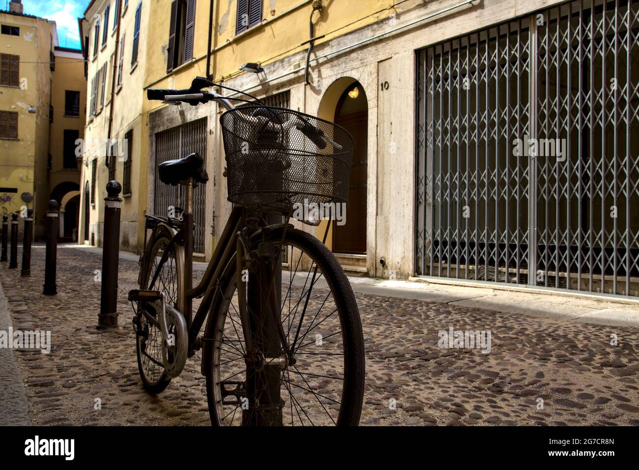 Bike in a shady street with closed shops Stock Photo - Alamy