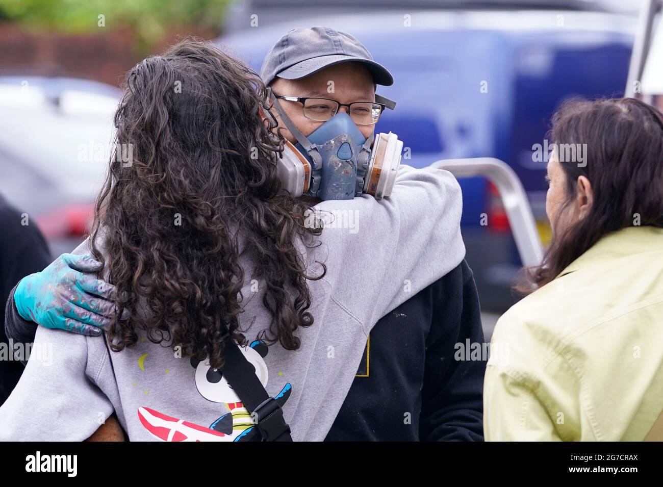 Street artist Akse P19 is given a hug after he repaired the mural of ...