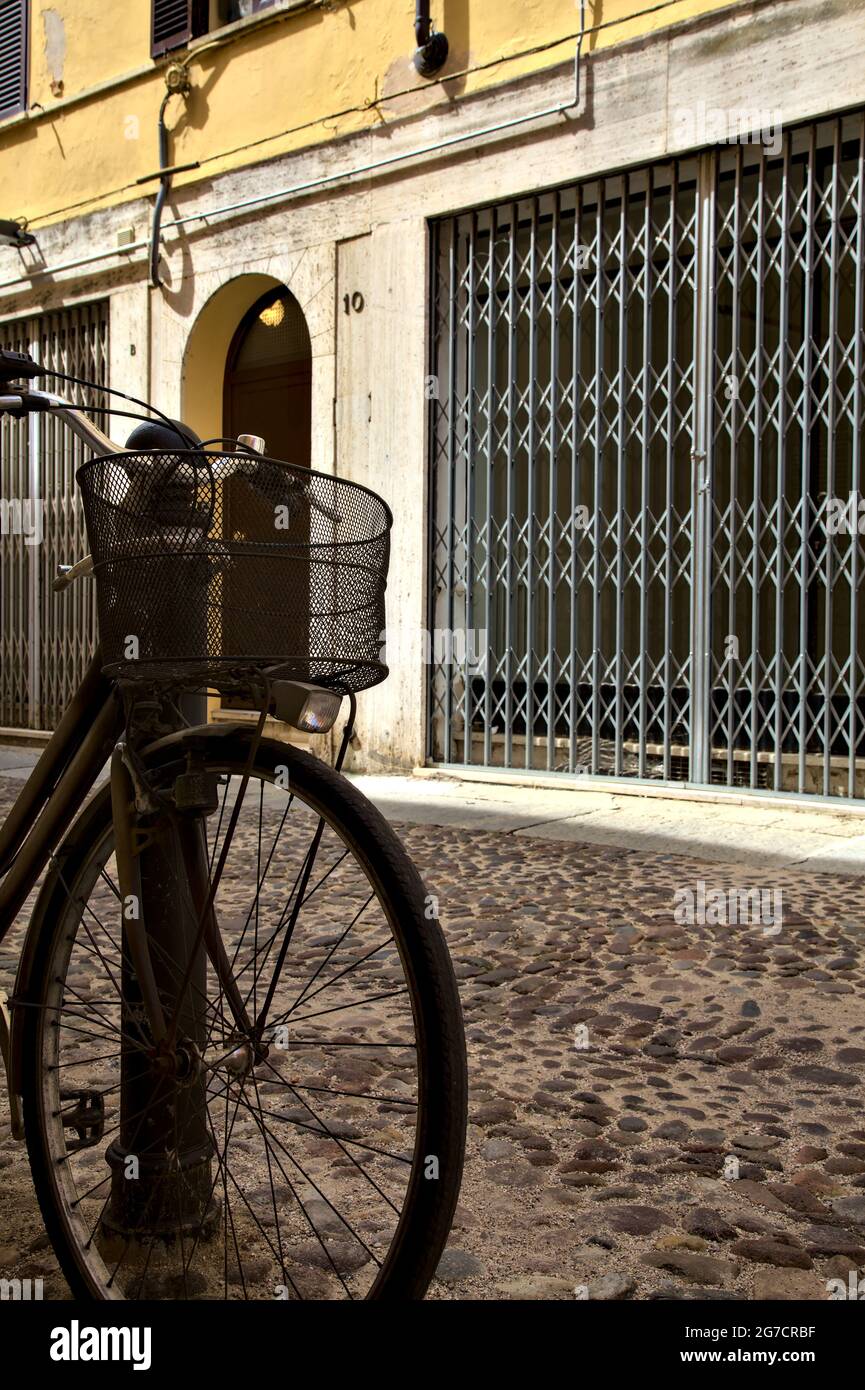 Bike in a shady street with closed shops Stock Photo - Alamy