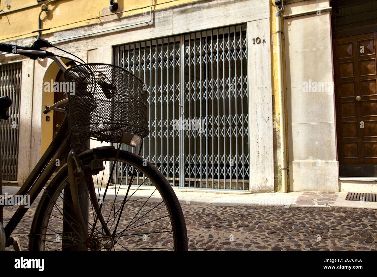 Bike in a shady street with closed shops Stock Photo - Alamy