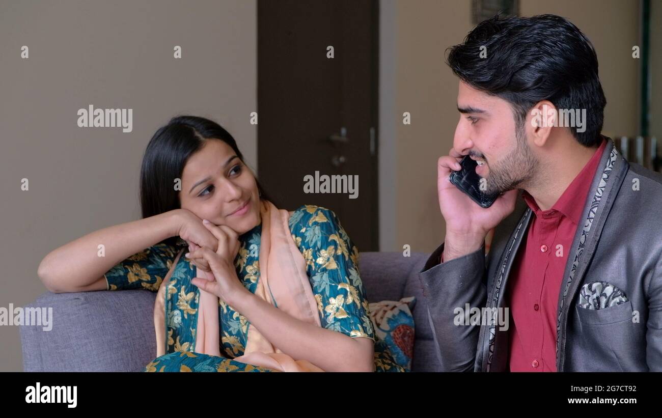 Shallow focus of an Indian man talking on the phone the woman looking ...