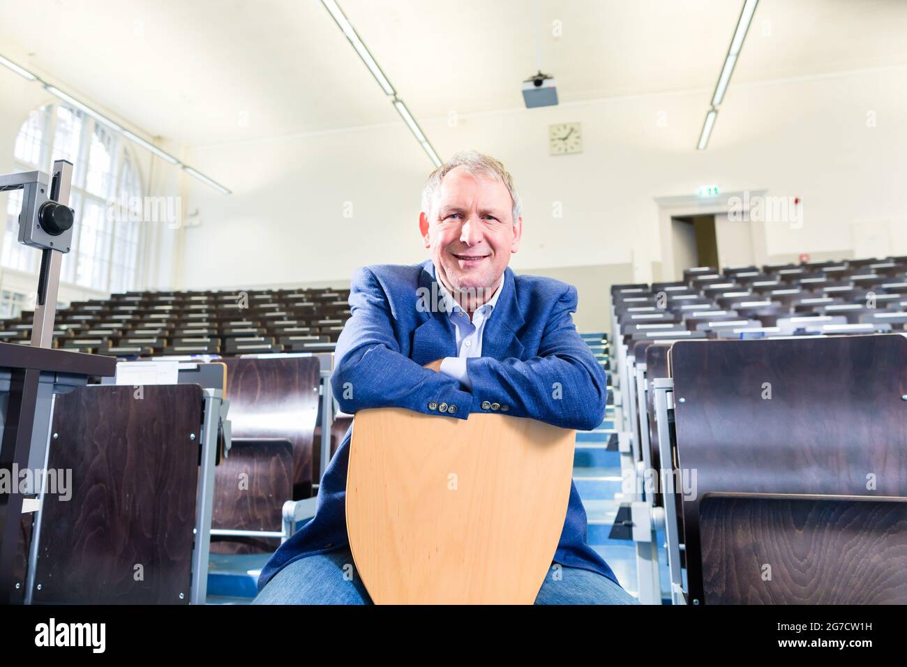 College professor giving lecture and standing at desk Stock Photo - Alamy