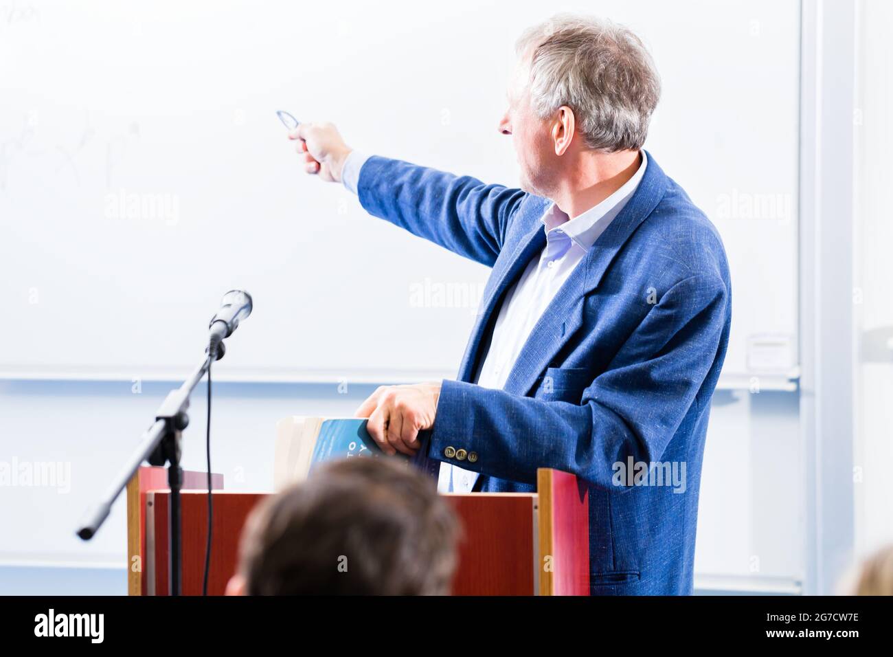 College professor giving lecture for students standing at desk Stock ...