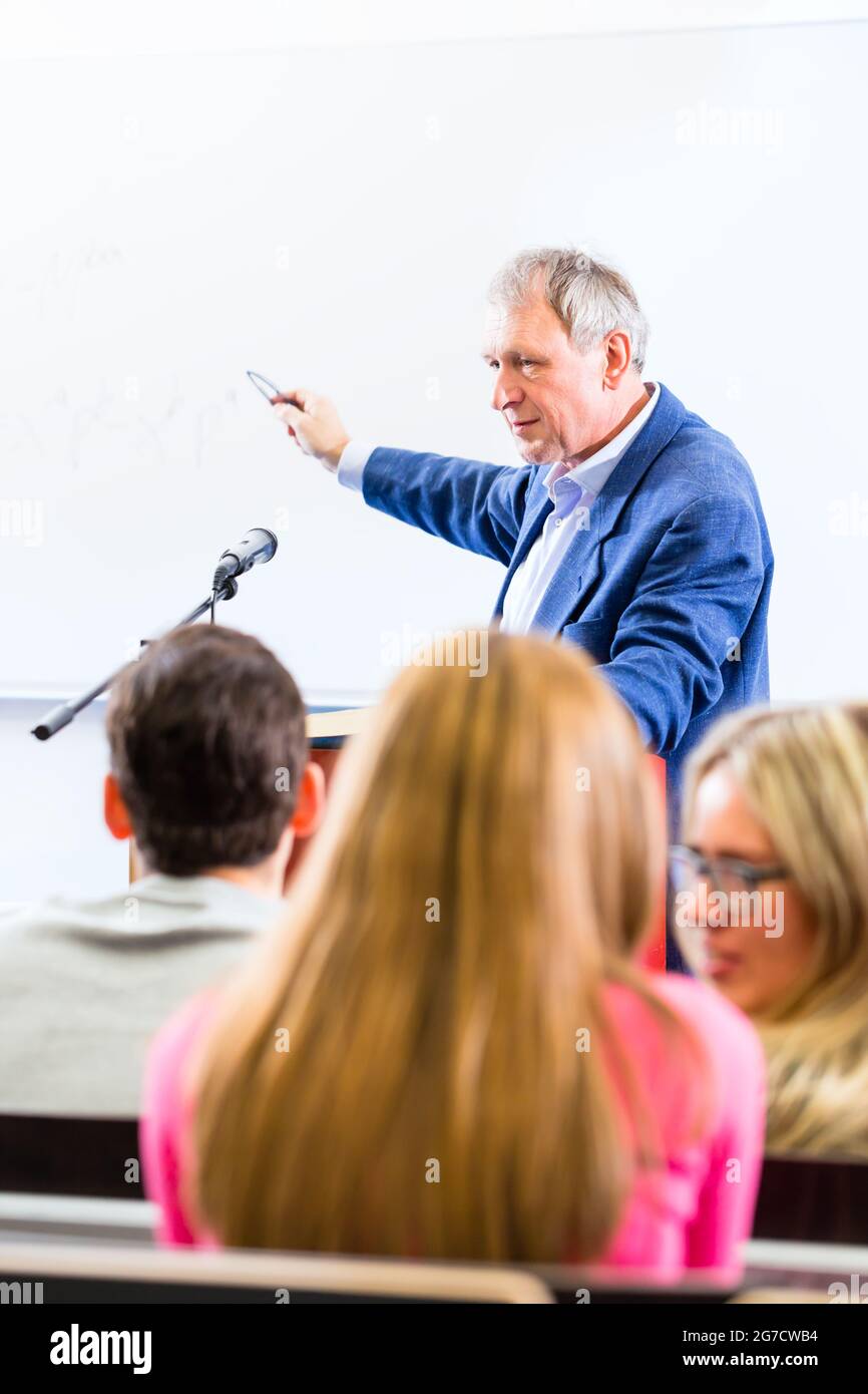 College professor giving lecture for students standing at desk Stock ...