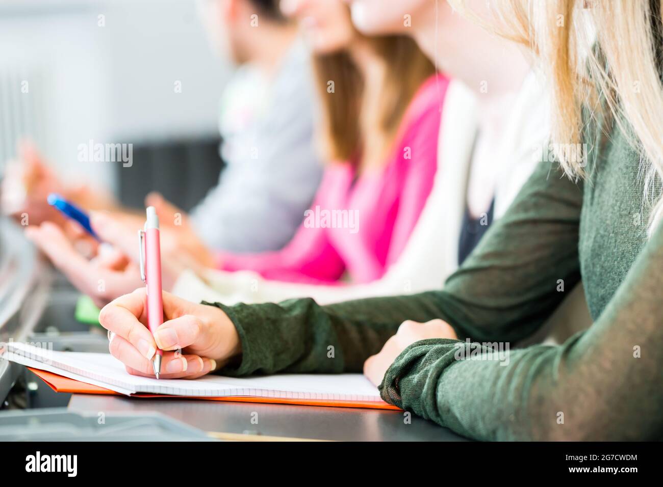 College students making lesson notes in university auditorium Stock ...