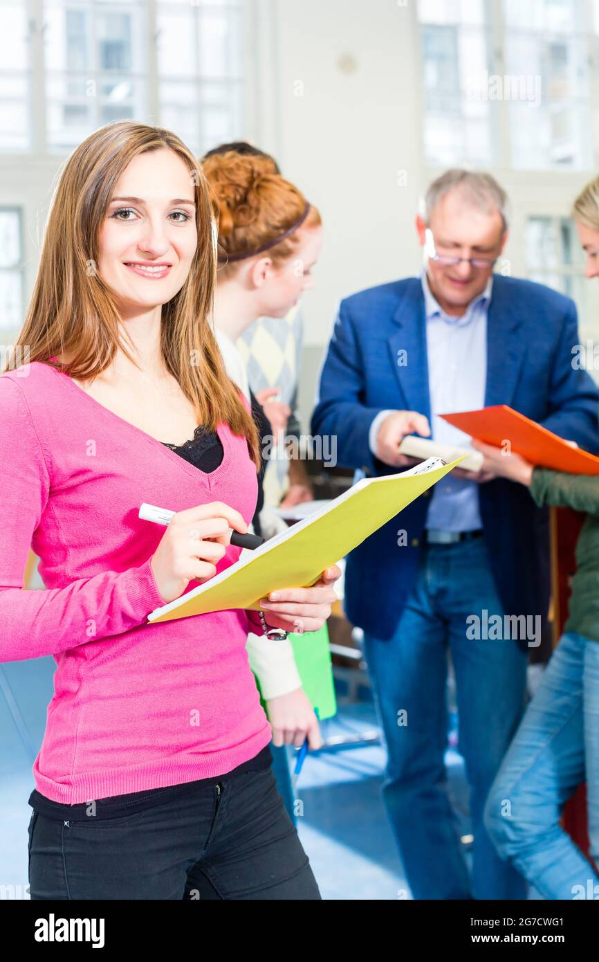 College students asking professor in university auditorium after ...