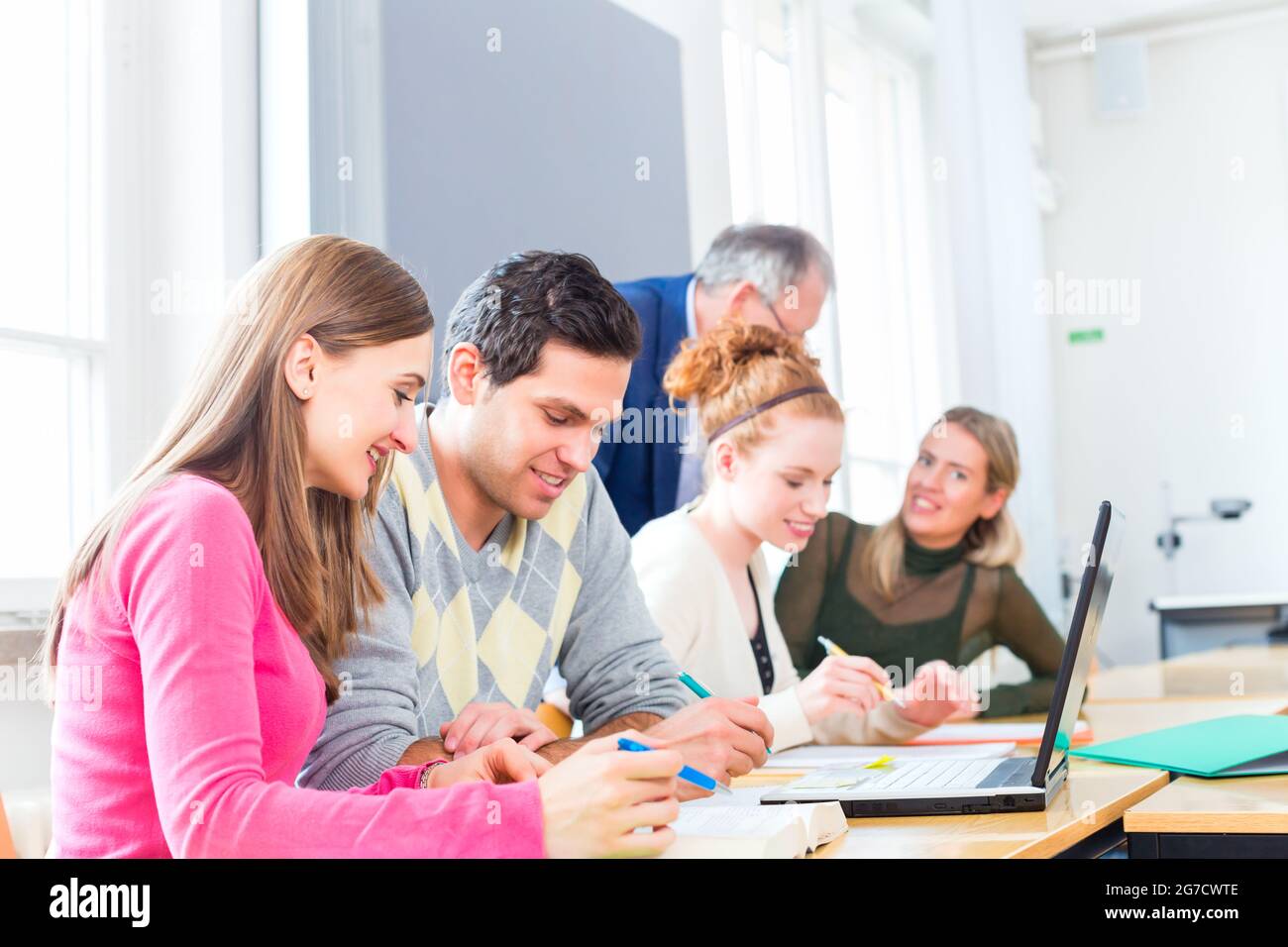 University college students with professor in seminar using laptop for ...
