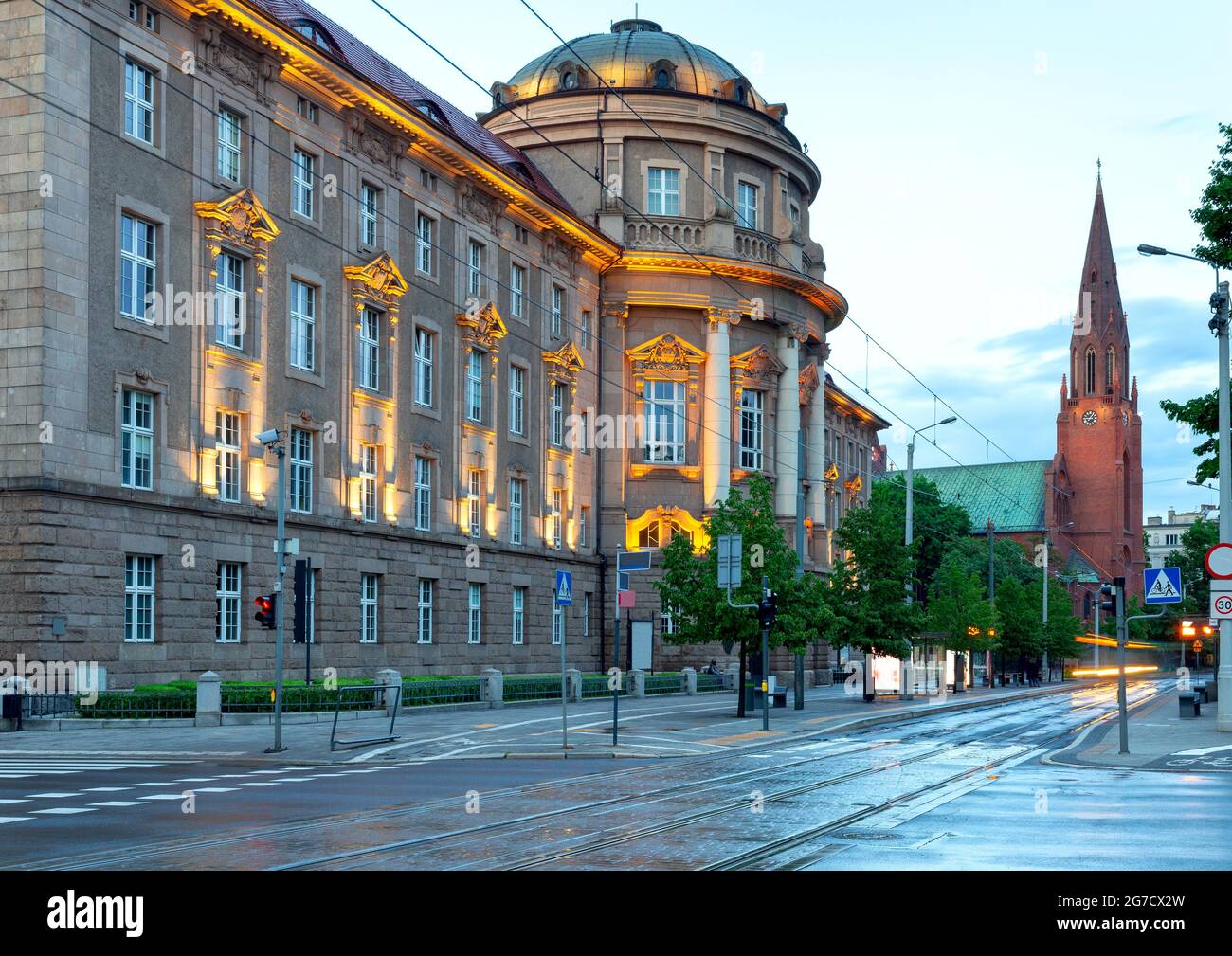 Facade of a beautiful old stone building and public garden at sunset ...