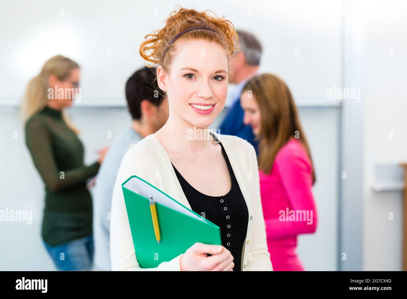 Student in college standing in front of learning group with professor ...