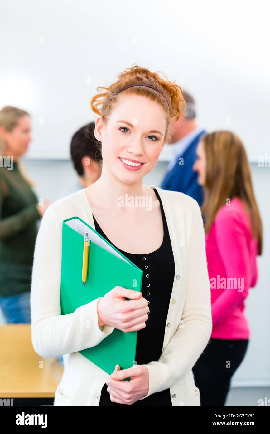 Student in college standing in front of learning group with professor ...