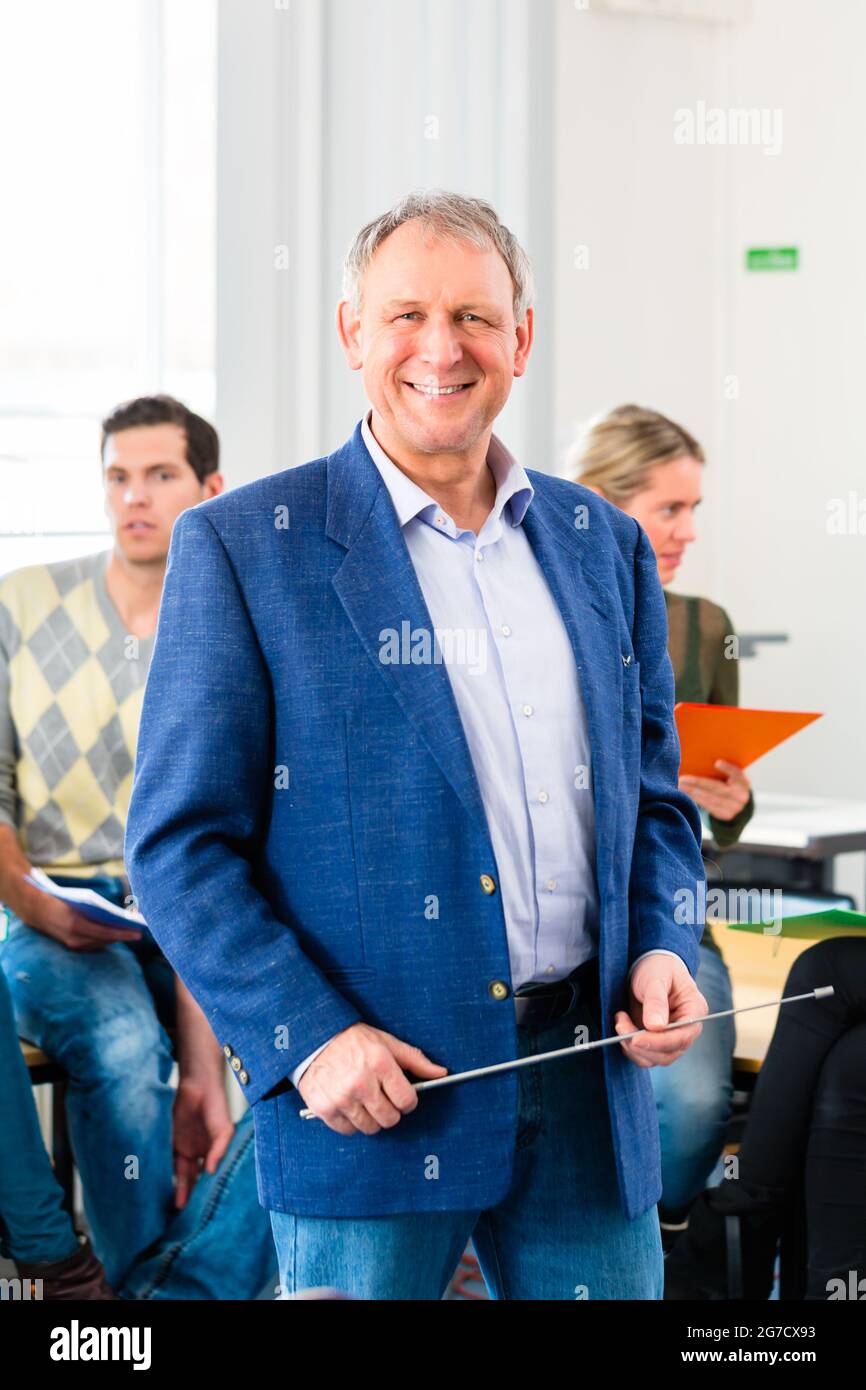 University college professor standing in class room Stock Photo - Alamy