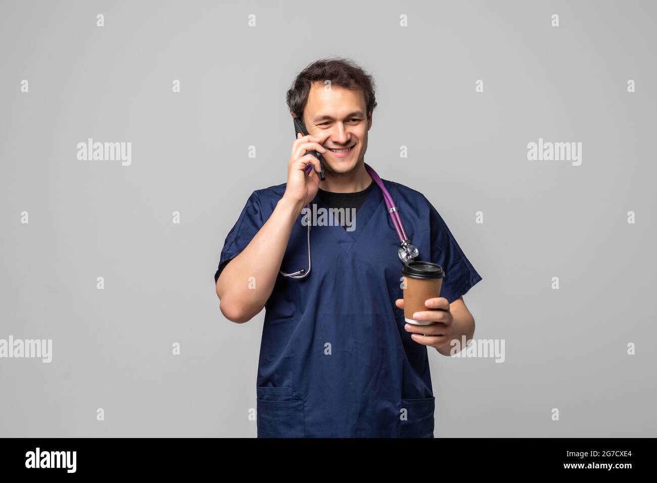 Smart and busy medic or doctor multitasking with phone on white ...