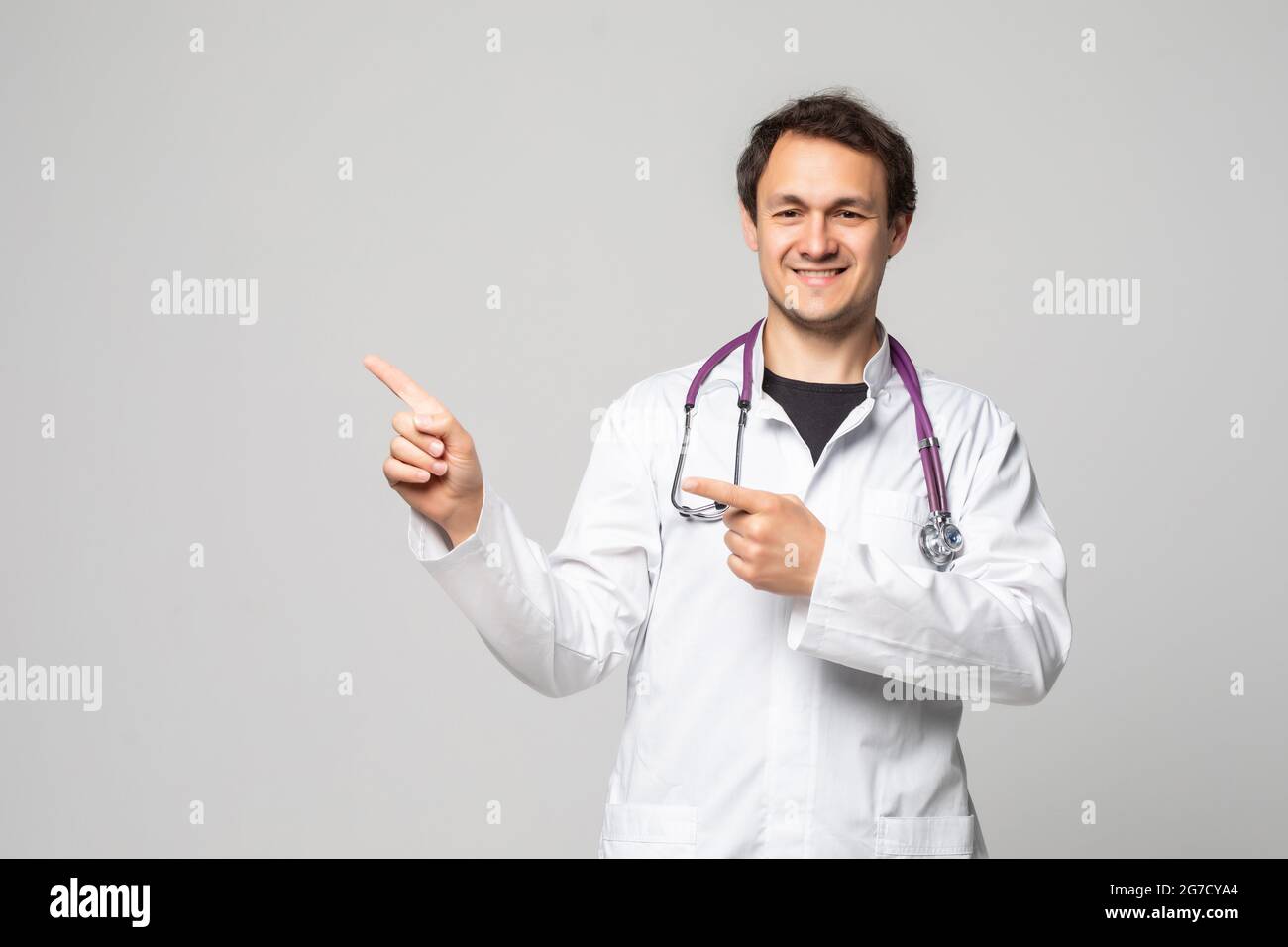 Doctor man presenting an advice pointing and looking at side isolated ...
