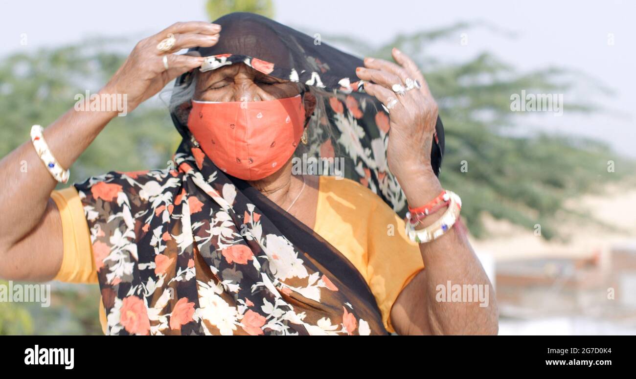 Old Indian woman wearing a traditional sari and face mask- new normal ...