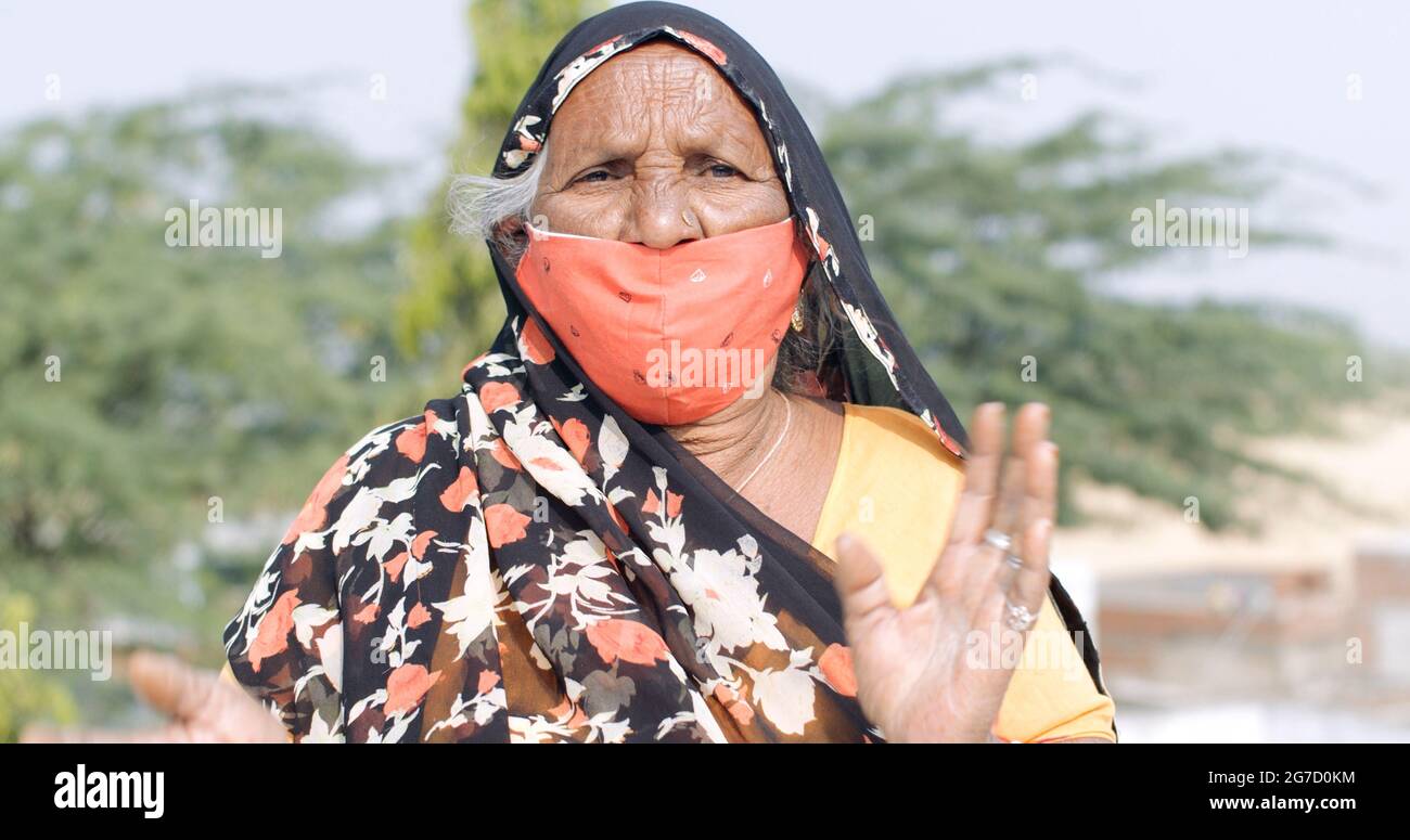 Old Indian woman wearing a traditional sari and face mask- new normal ...