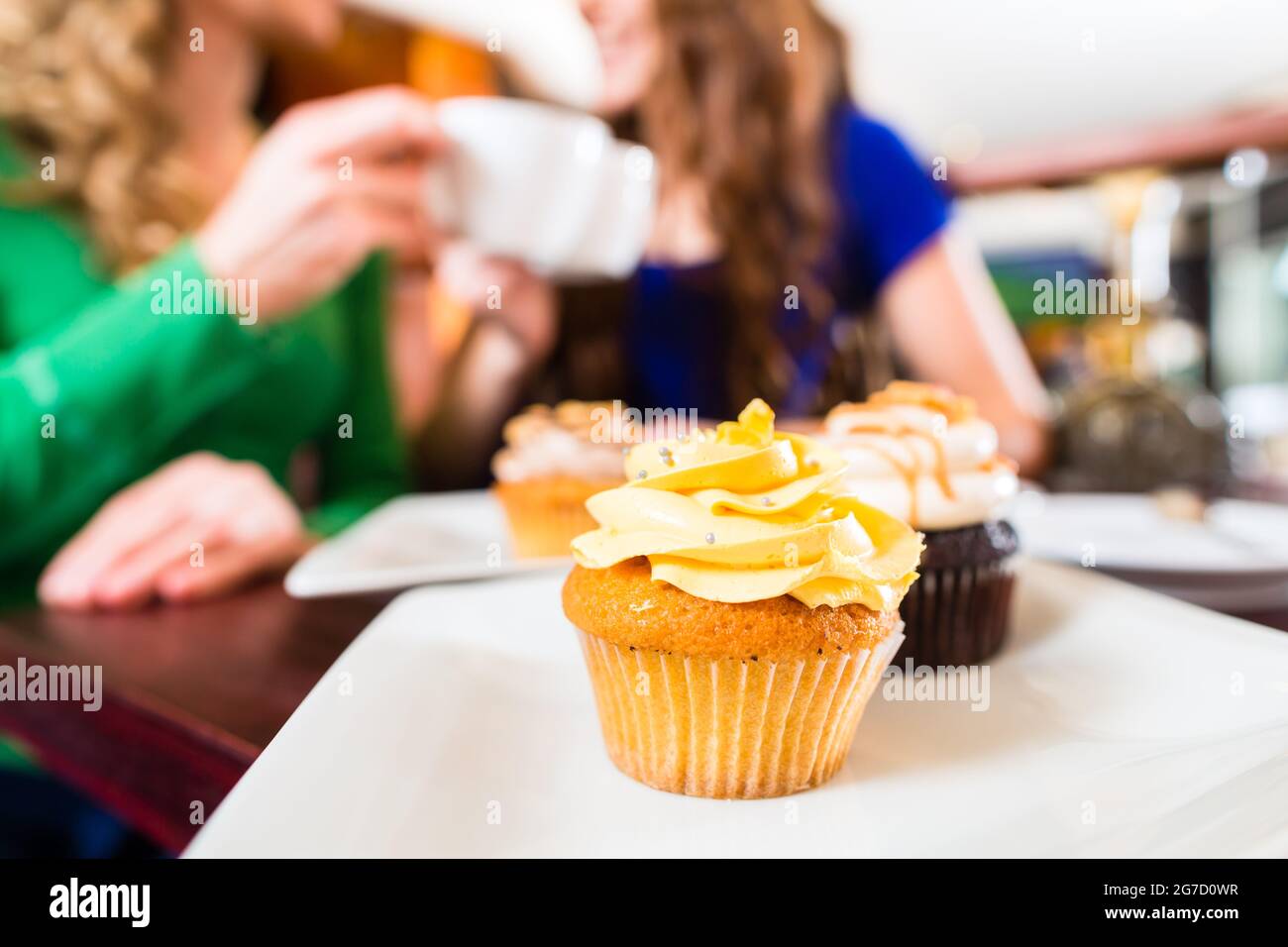 Friends having fun and eating muffins at bakery or pastry shop Stock ...