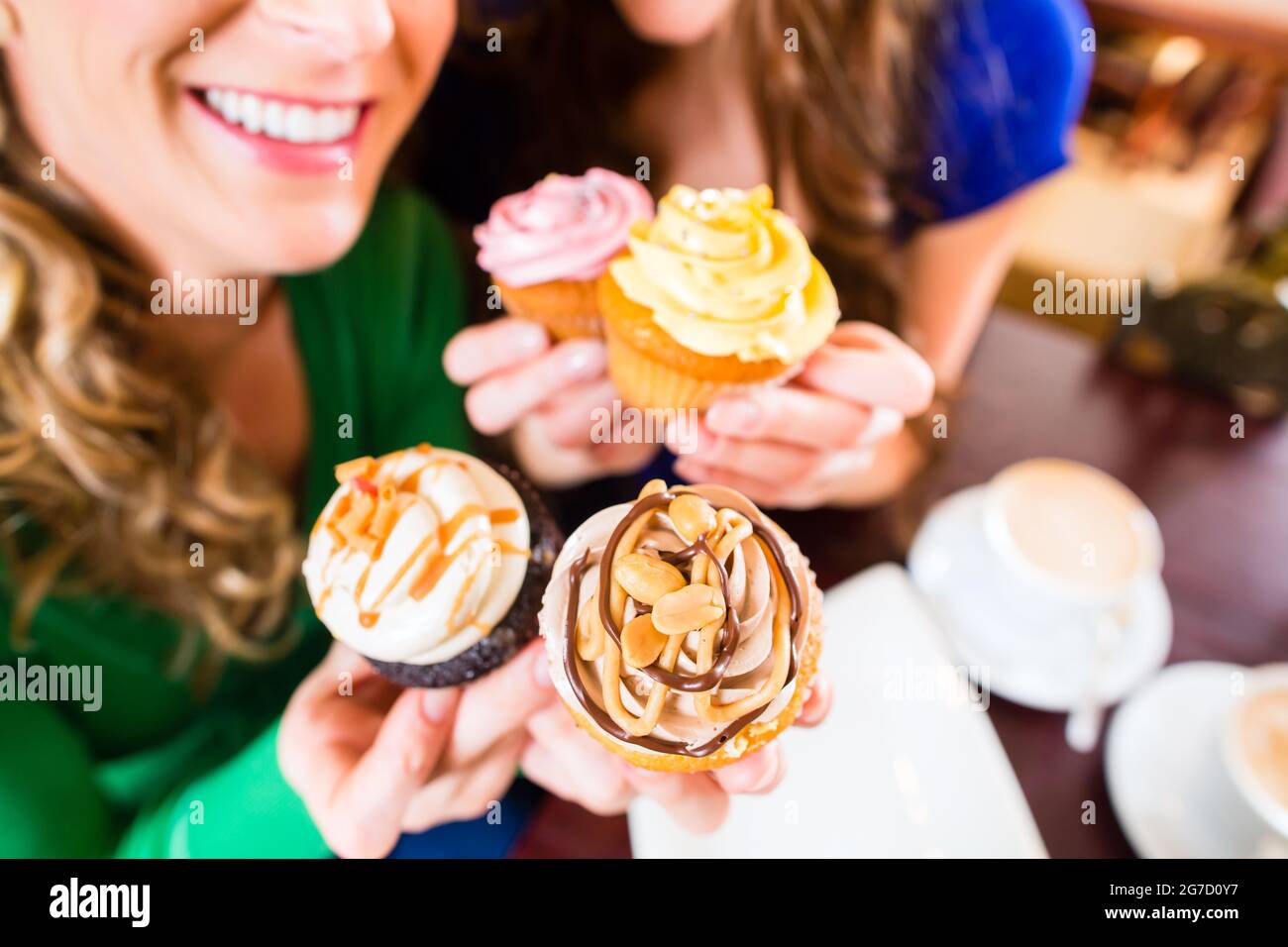 Friends having fun and eating muffins at bakery or pastry shop Stock ...