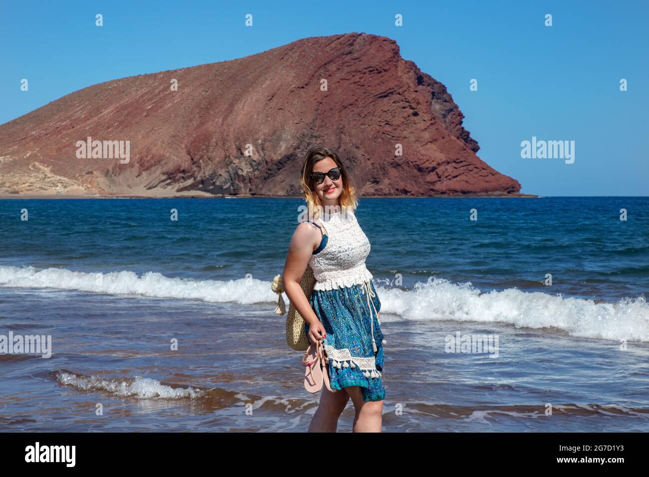 Portrait of an exuberant young millennial woman wearing a blue and ...