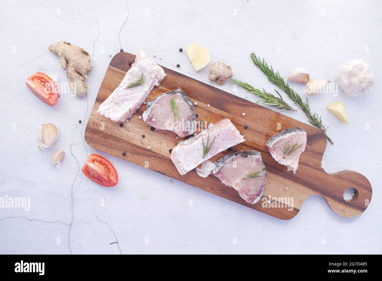 raw fresh fish on a chopping board for preparing for cooking on table ...