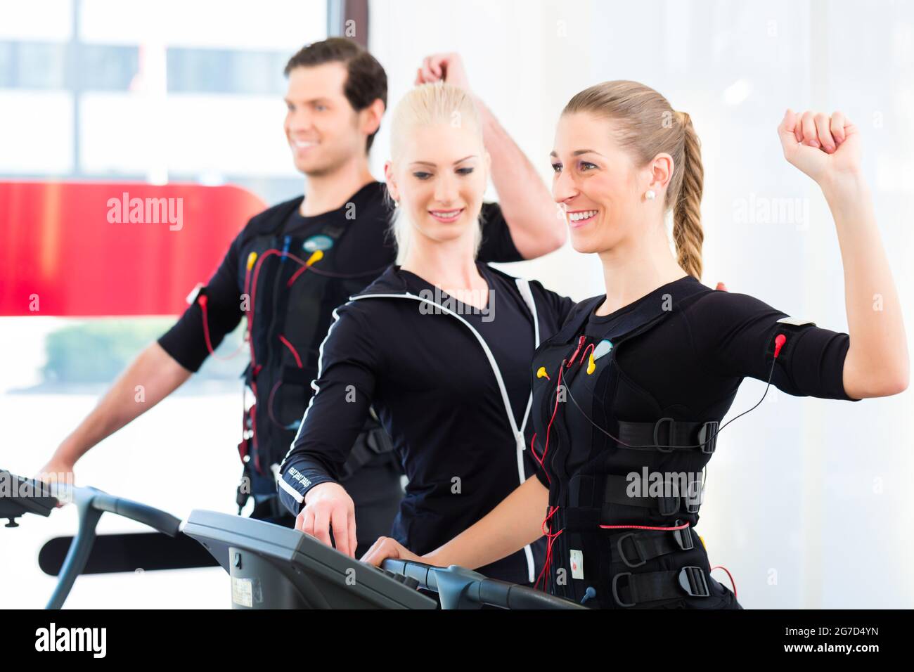 Female coach giving man and woman ems electro muscular stimulation ...