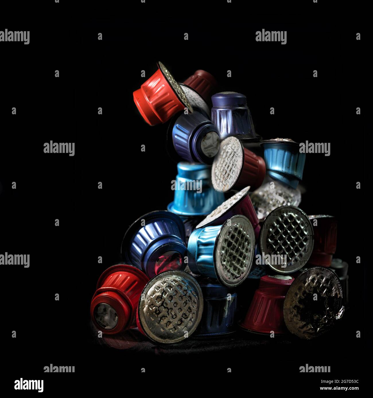 Pile of colorful used coffee capsules against a black background, a lot ...