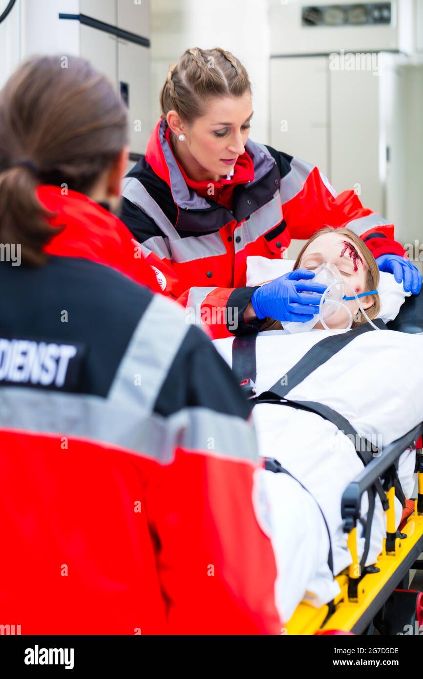 Emergency doctor and nurse or ambulance team transporting accident ...