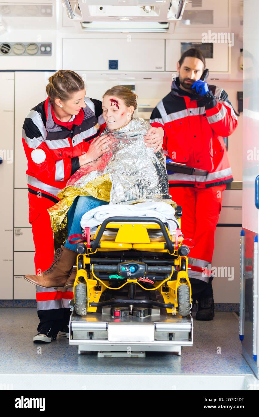 Emergency doctor and paramedic or ambulance team helping accident ...