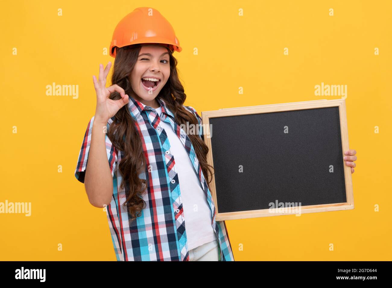 winking kid in helmet presenting school blackboard with advertisement ...