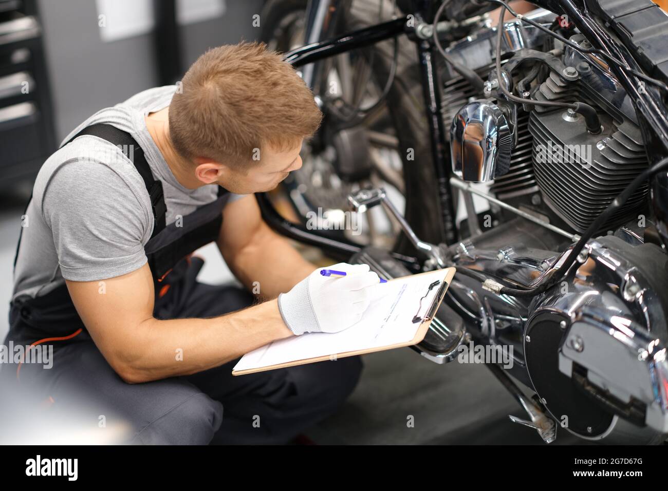 Foreman in service repair center diagnoses parts on motorcycle Stock ...