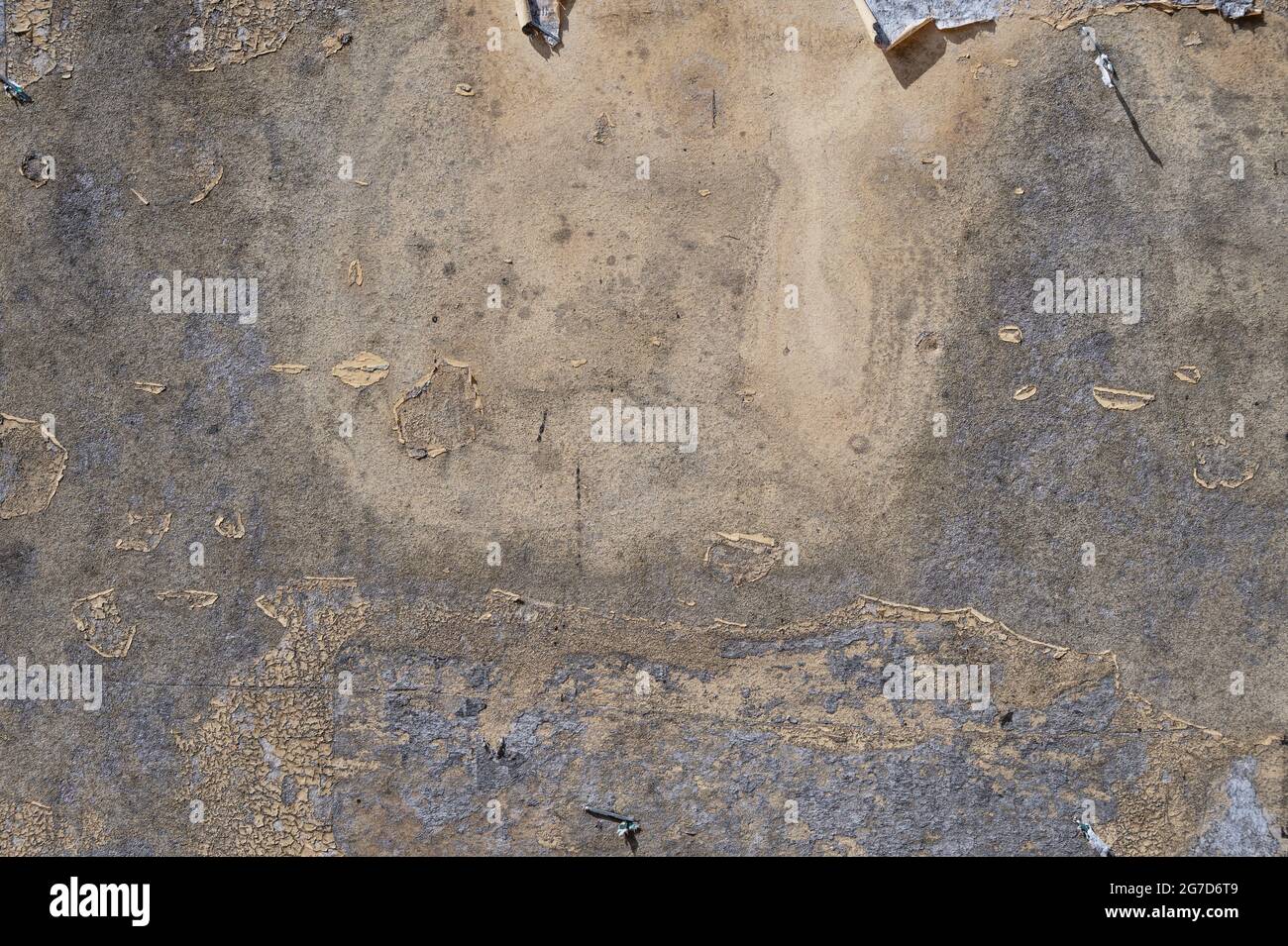old weathered poster wall from pressboard with rests of ripped paper ...