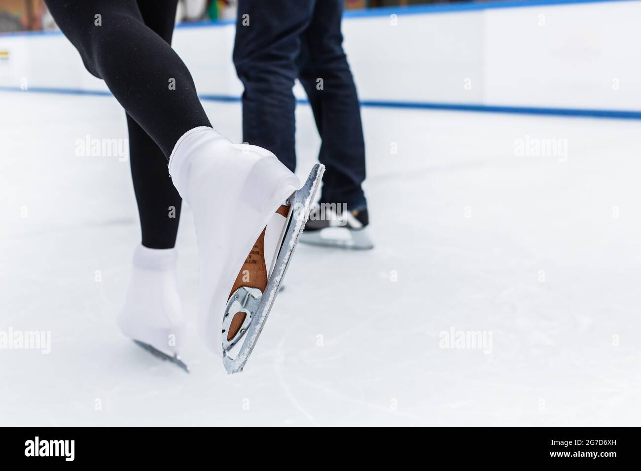 Close-up of ice skaters leg skating on ice rink Stock Photo - Alamy