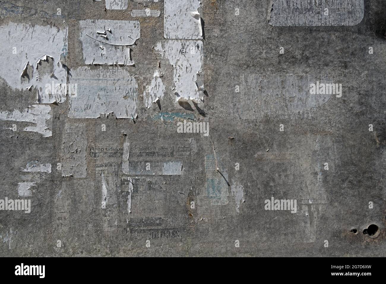 Surface of an old weathered bulletin board with remnants of torn paper ...