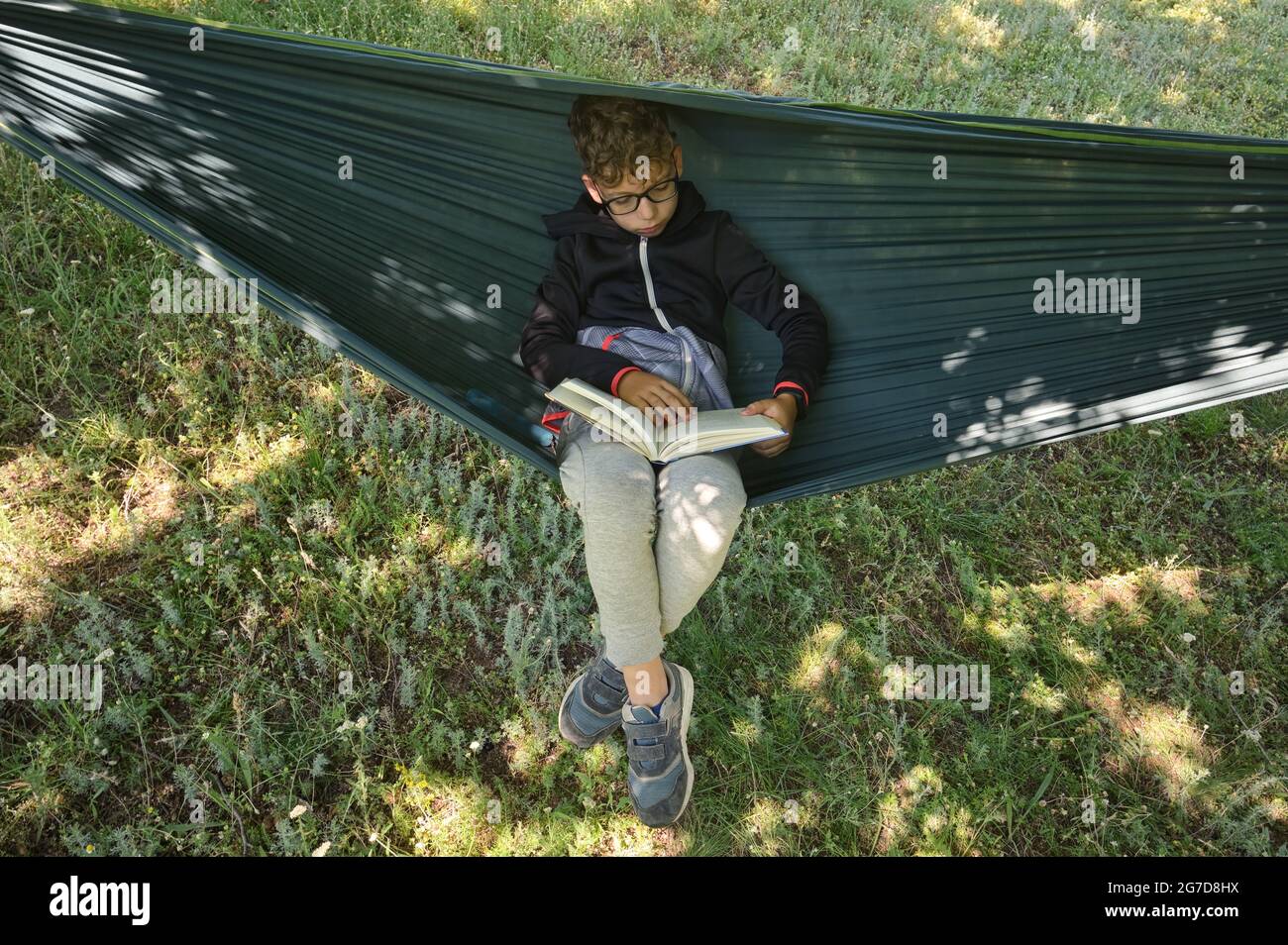 Boy reading book hammock hi-res stock photography and images - Alamy