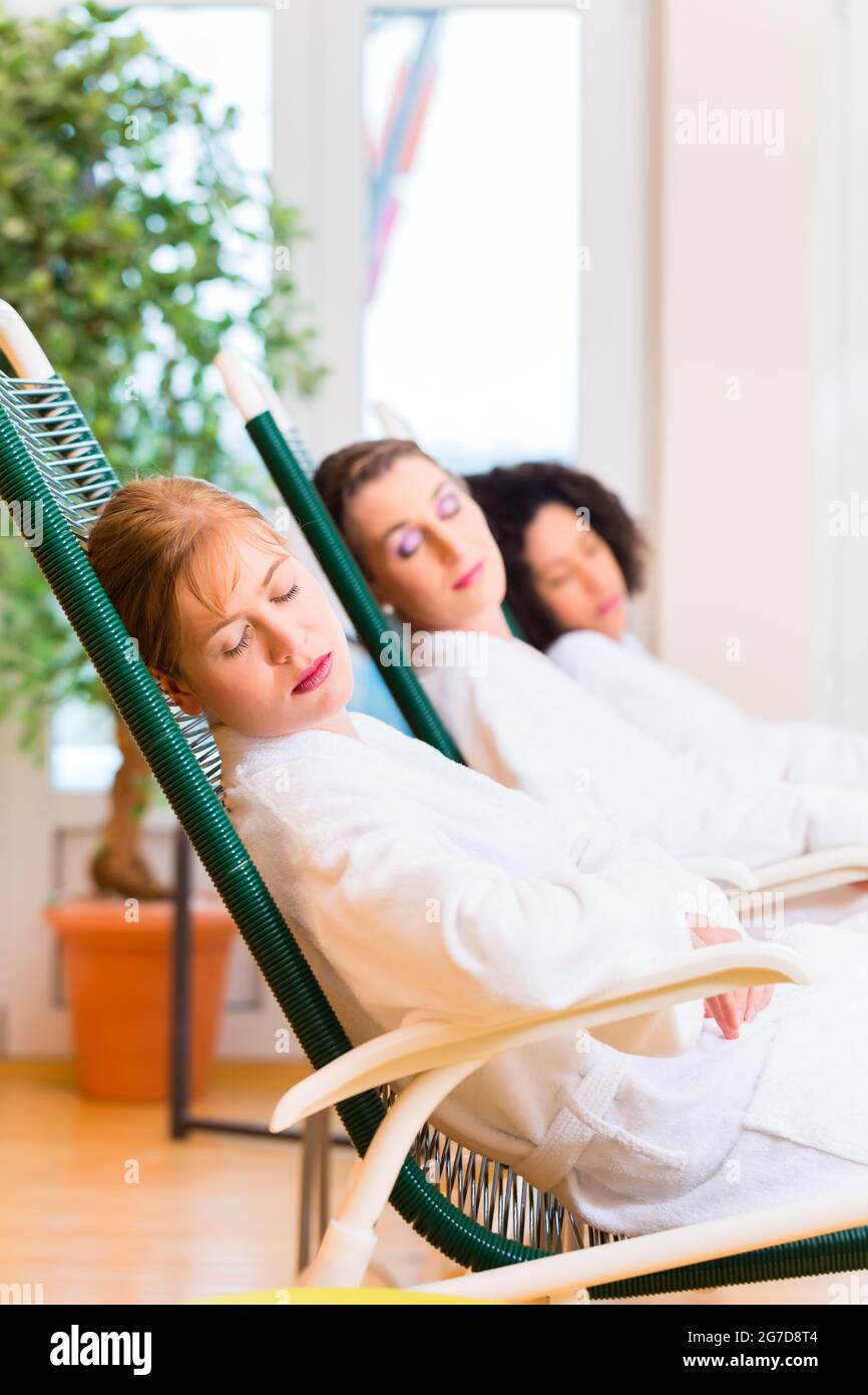 Friends relaxing and sleeping in relaxation room on lounger of wellness ...