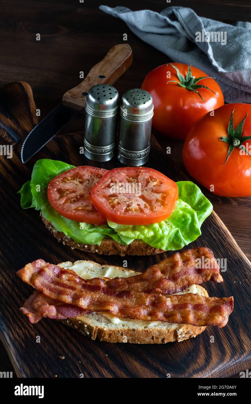 Vertical view of a homemade open bacon and tomato sandwich with ...