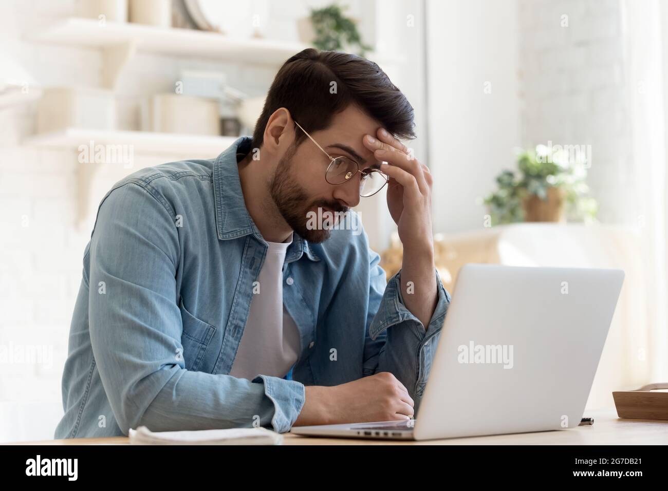 Man looks at laptop screen feels confused experiencing problems Stock ...