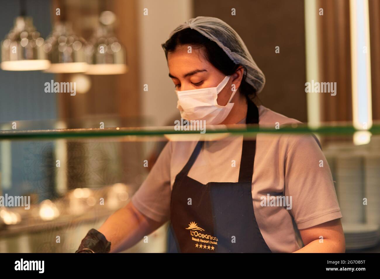 Kemer, Turkey - May, 24: Young women waiter in mask gives out food ...