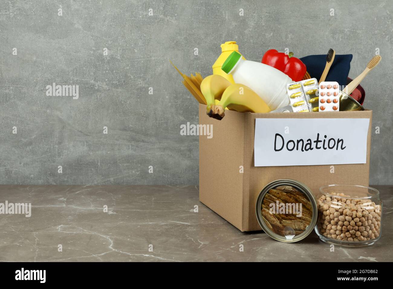 Concept of donate with donation box on gray textured table Stock Photo ...