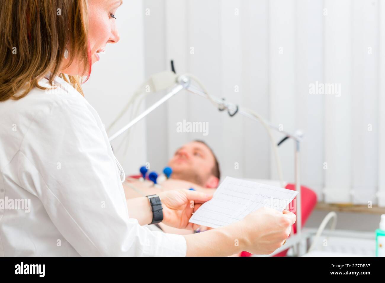 Female doctor analyzing ECG electrocardiogram of patient in hospital ...