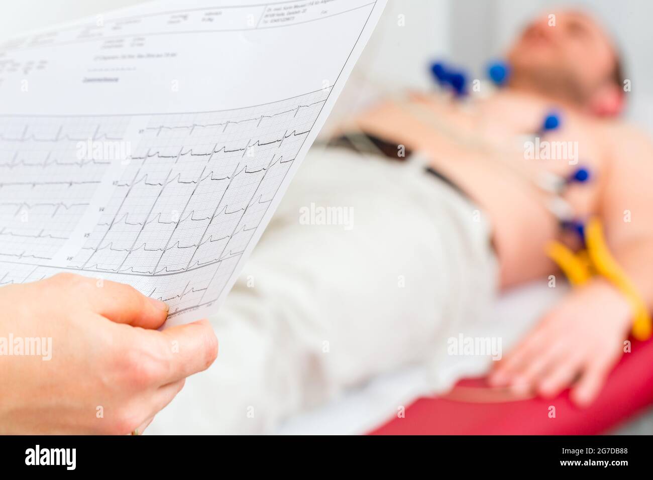 Female doctor analyzing ECG electrocardiogram of patient in hospital ...