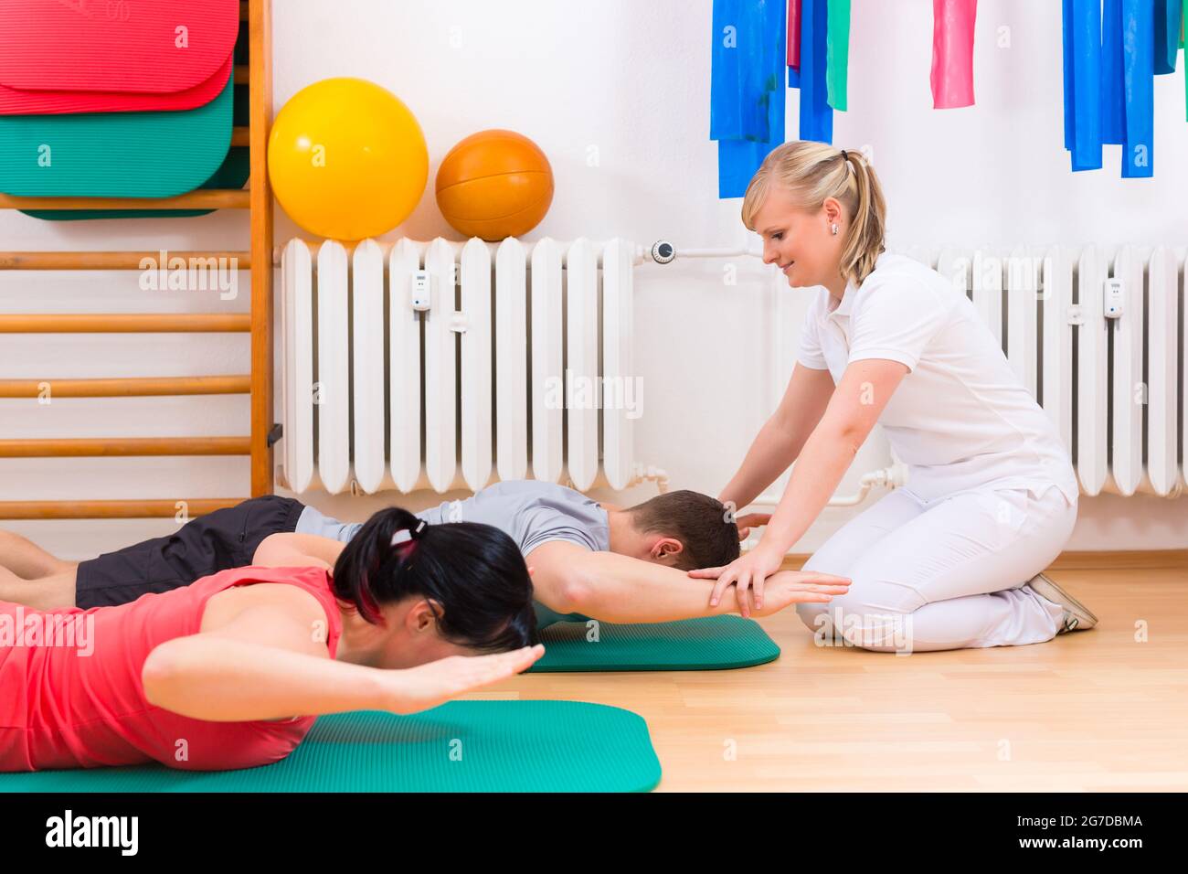 Patients at the physiotherapy doing physical exercises with therapist ...