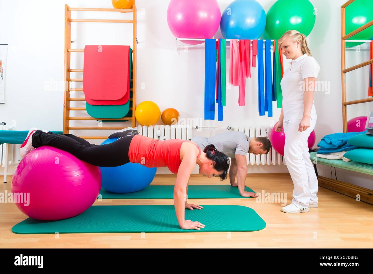 Patients at the physiotherapy doing physical exercises with therapist ...