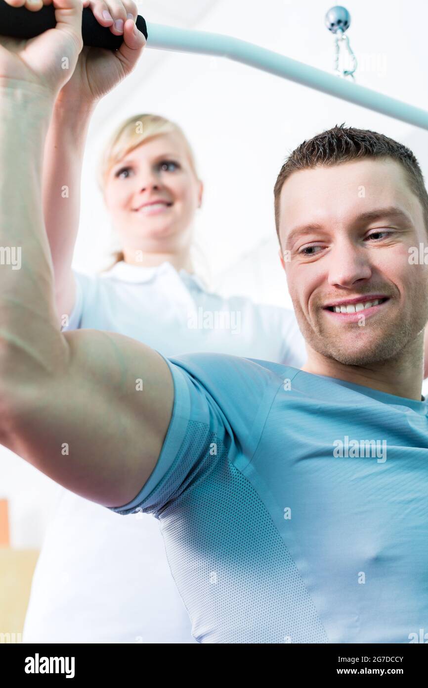 Patient at the physiotherapy doing physical exercises with therapist in ...