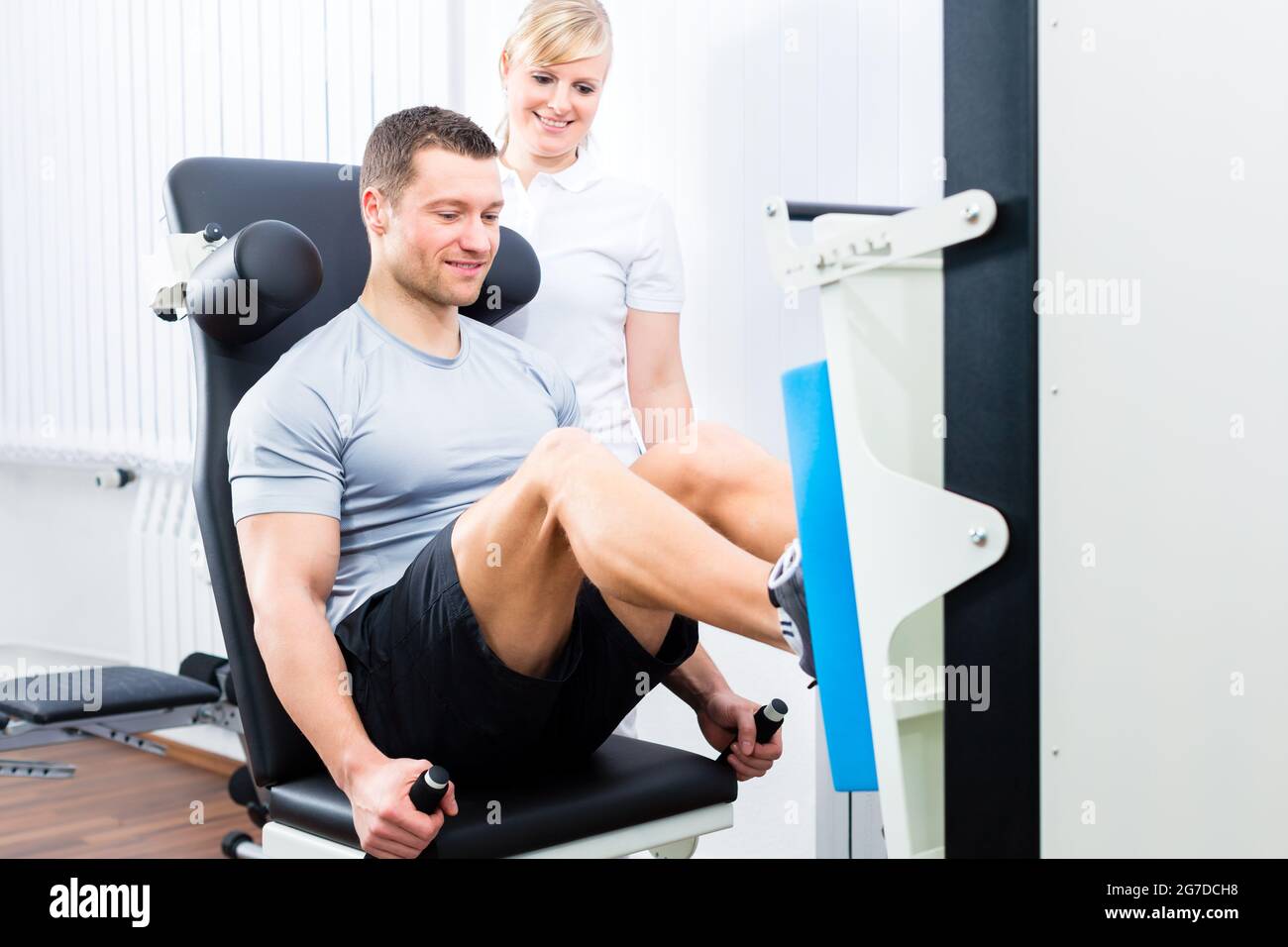 Patient at the physiotherapy doing physical exercises using leg press ...