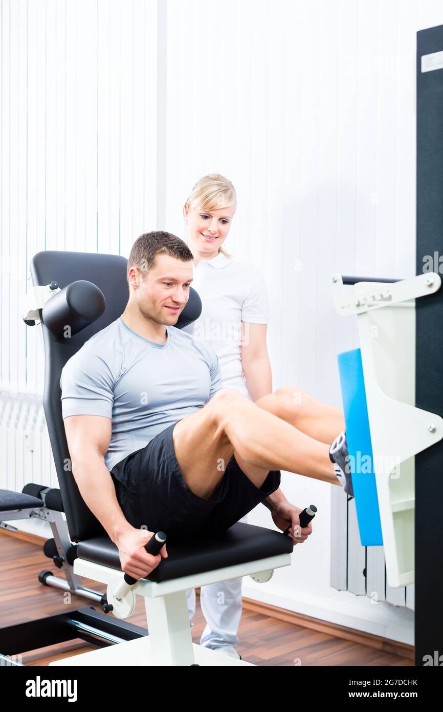 Patient at the physiotherapy doing physical exercises using leg press ...